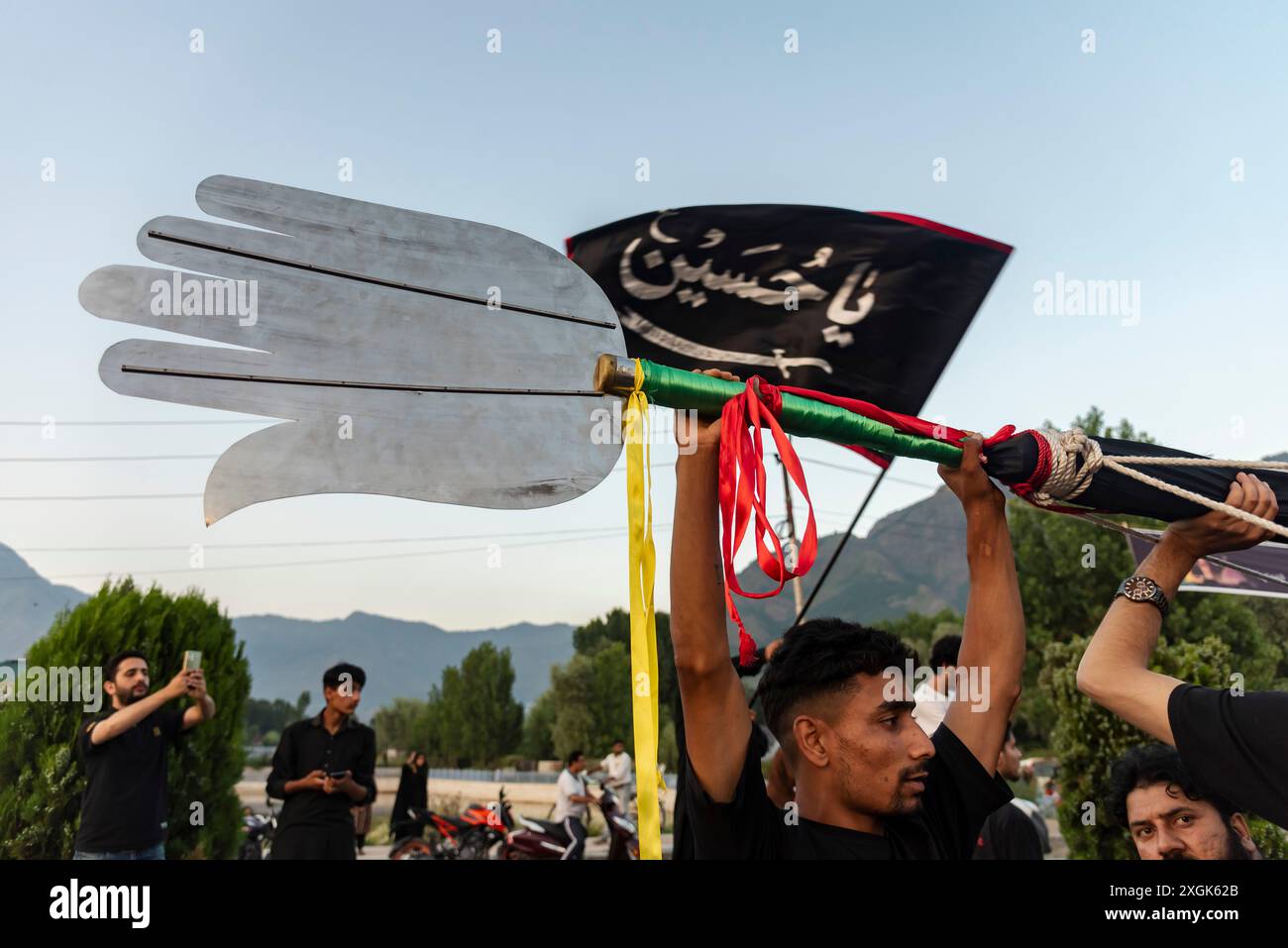 Kashmiri Shia Muslims install a tall religious flag on a road during ...