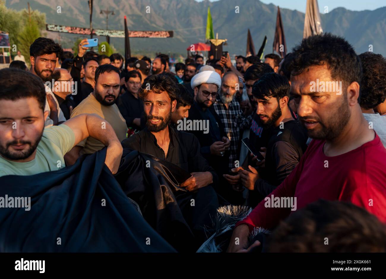 Kashmiri Shia Muslims prepare a religious flag to install on a road ...