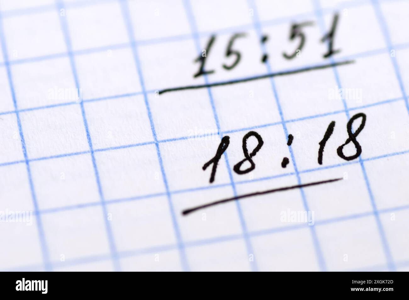 Repeating numbers are handwritten on a checkered sheet of paper. Close ...