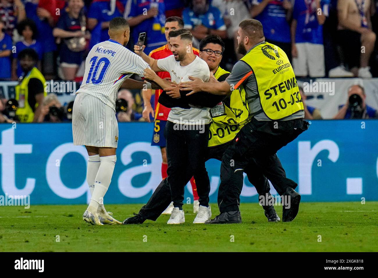 An invader stands near Kylian Mbappe of France during a semifinal match between Spain and France ...