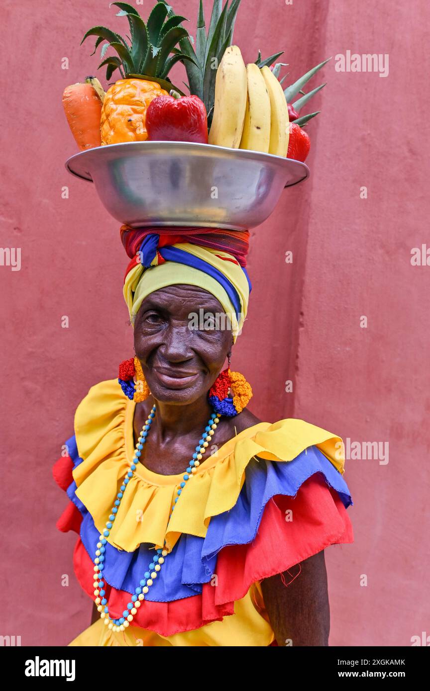 The Palenqueras of Cartagena, dressed in vibrant, colorful outfits with ...