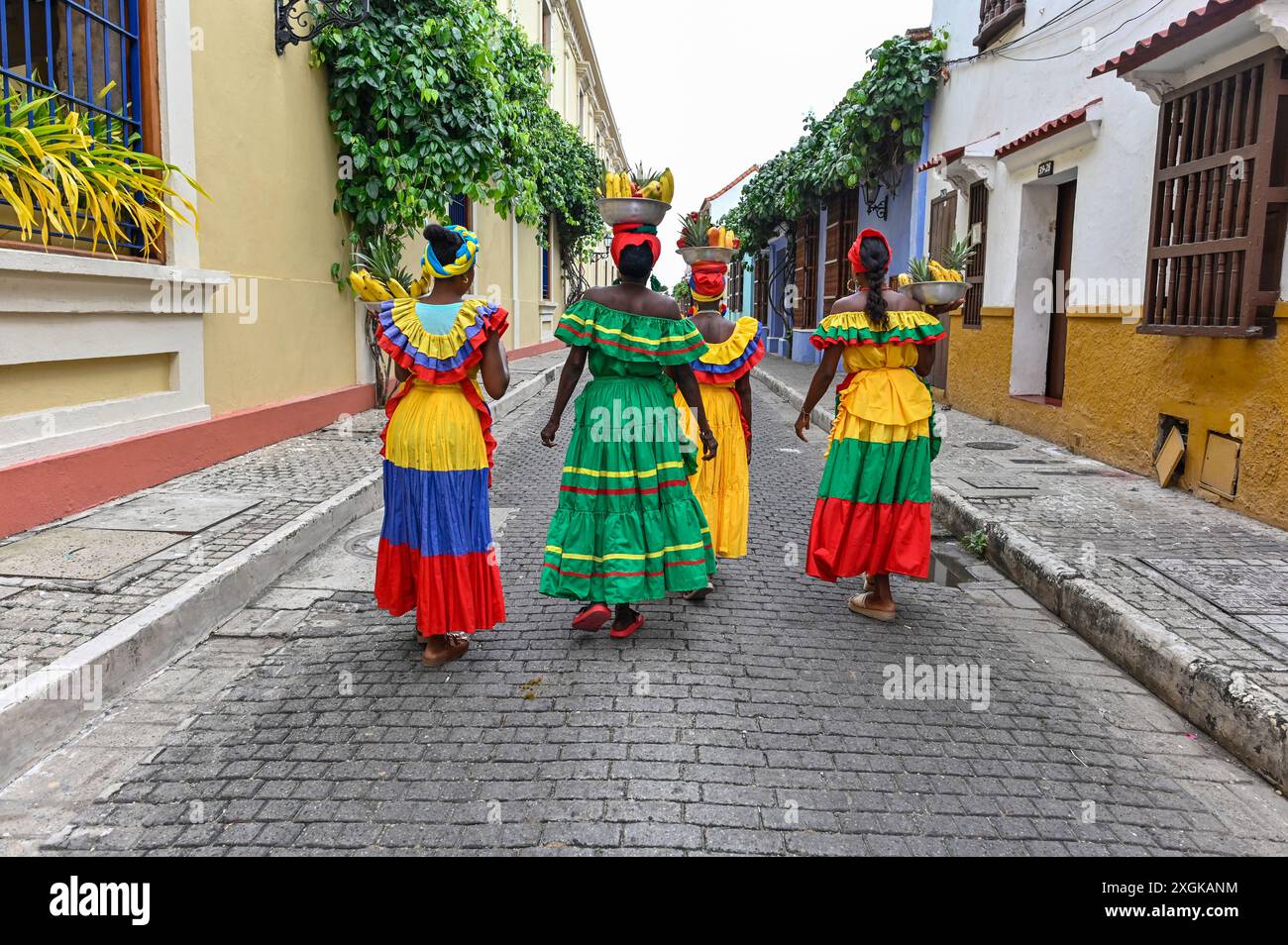 The Palenqueras of Cartagena, dressed in vibrant, colorful outfits with ...