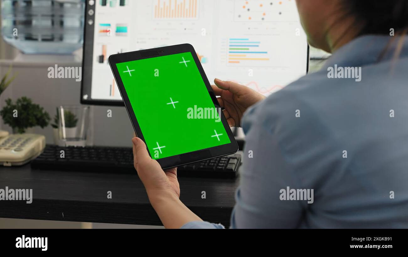 Office worker examines greenscreen layout in coworking space, working ...