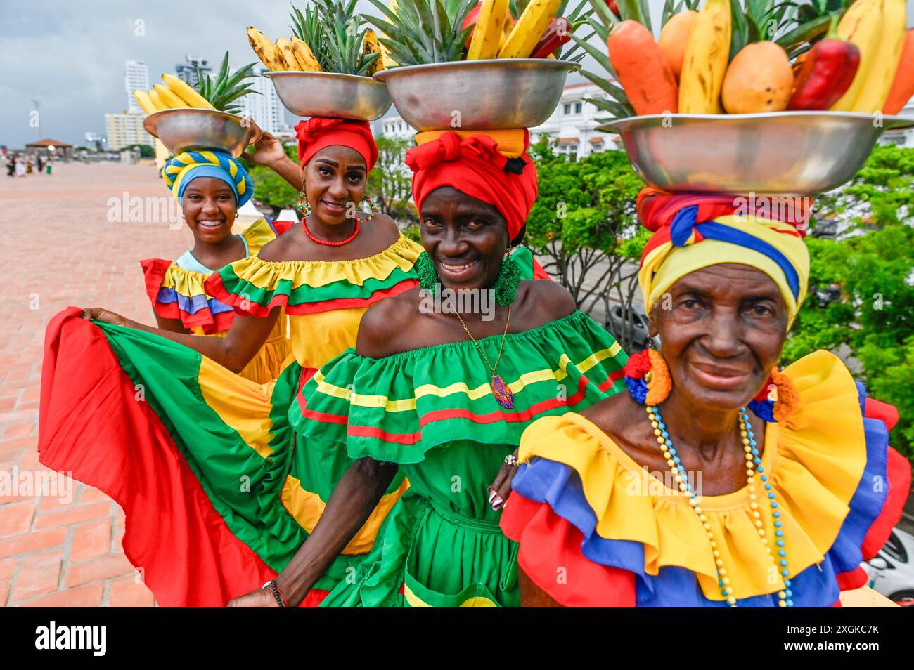 The Palenqueras of Cartagena, dressed in vibrant, colorful outfits with ...