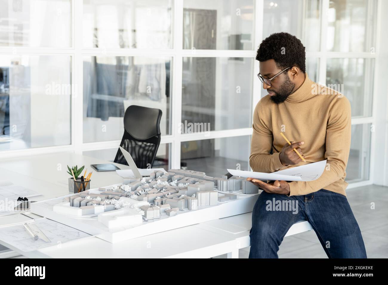 Skillful man architect solving engineers tasks in his modern workplace ...