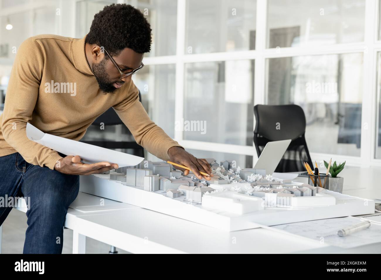 Successful man architect reviewing blueprints in his workplace Stock ...
