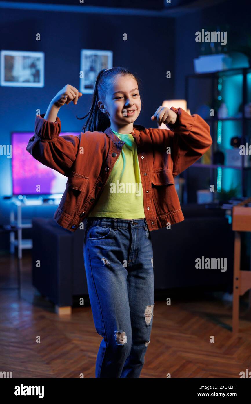 Cute girl performing trending dance routine in living room, surrounded ...