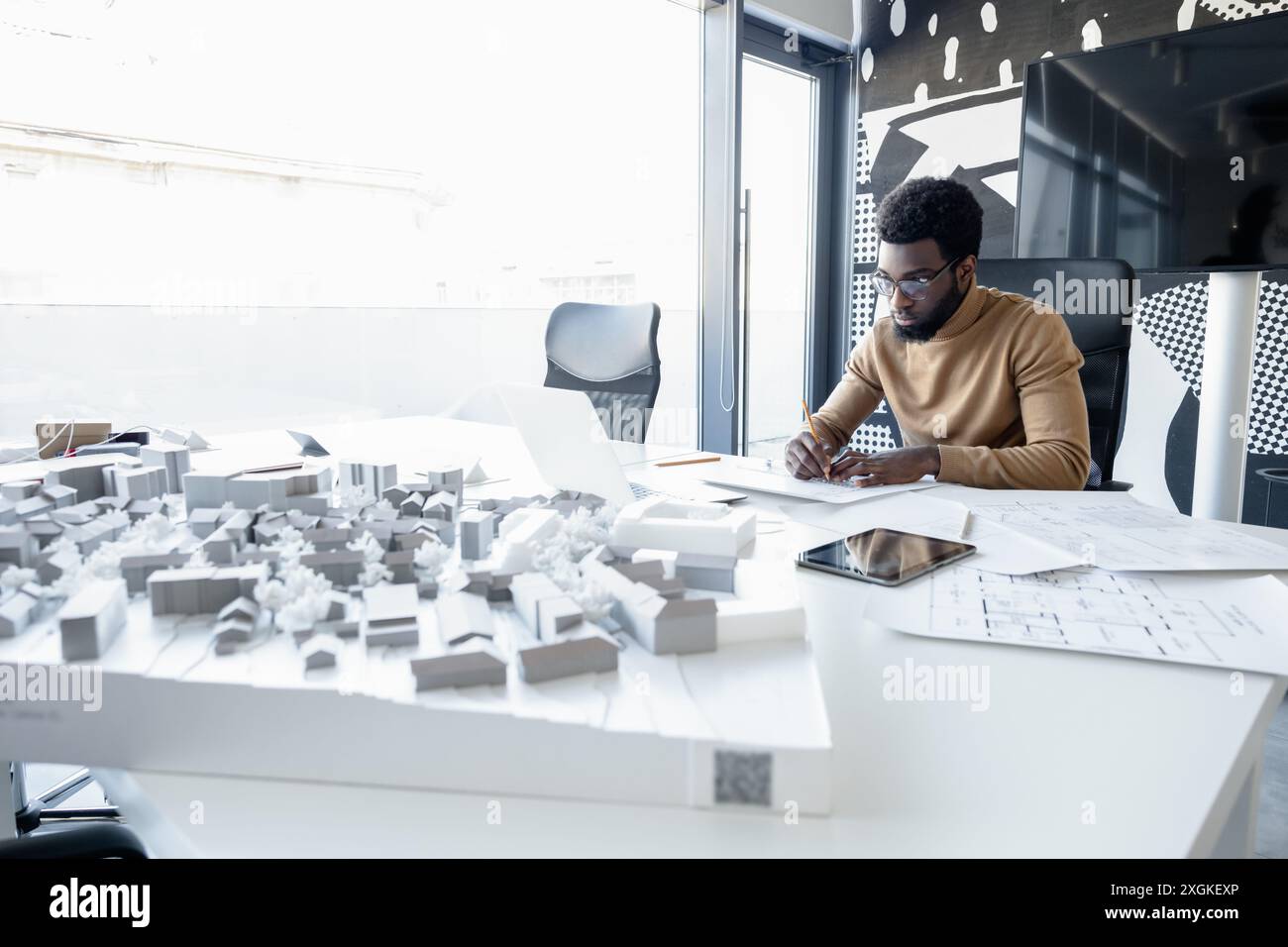 Hard working man architect handling creative projects in the office ...
