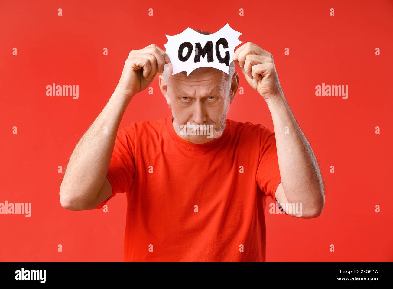 Shocked senior man holding speech bubble with word OMG on red ...