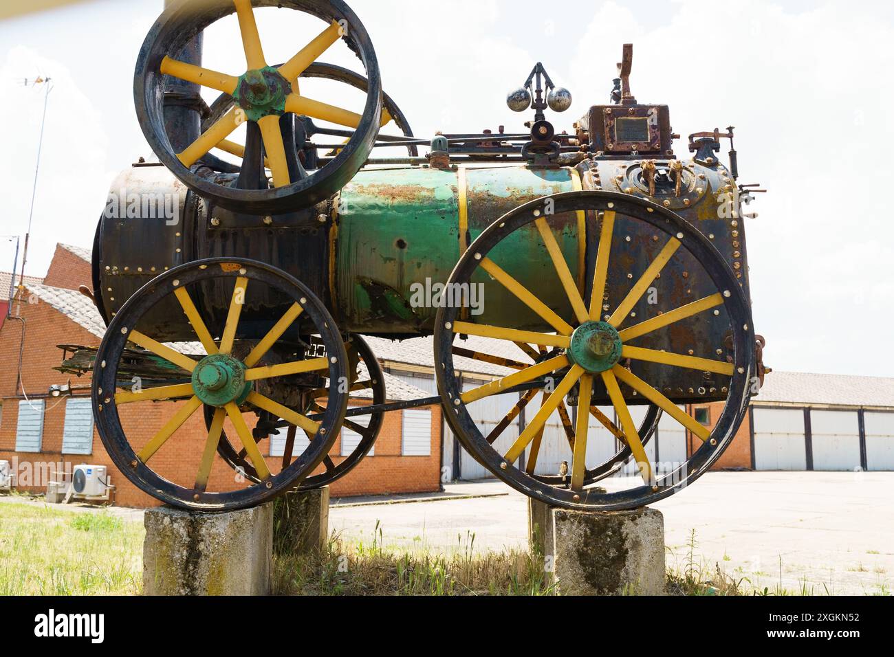 A weathered steam engine, with large wooden wheels and intricate ...