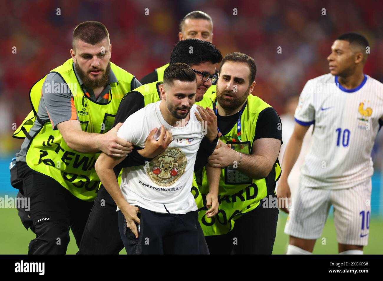 Munich, Germany. 09th July, 2024. A pitch invader is removed from the ...