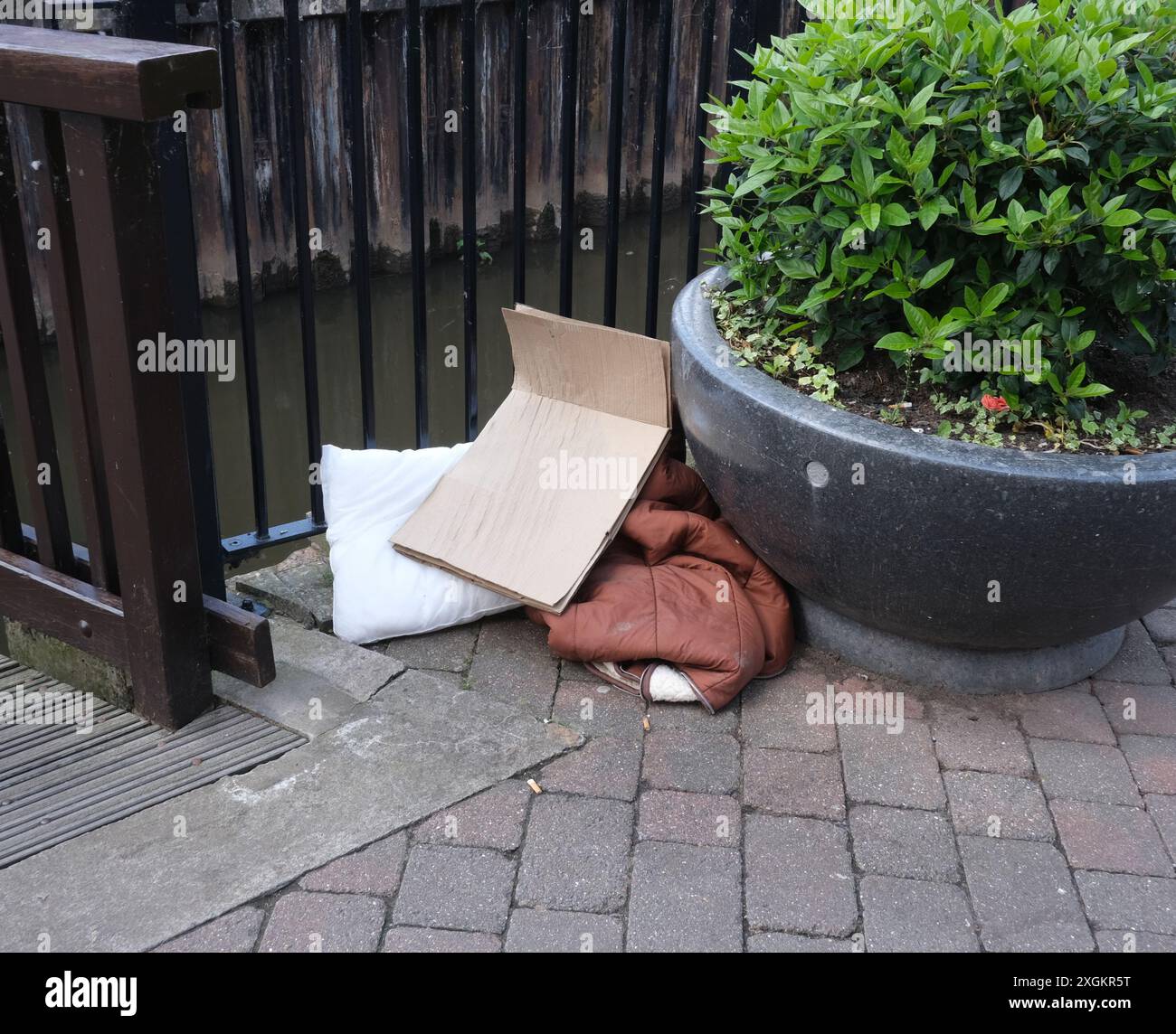 Sleeping bag, pillow and cardboard left on pavement by homeless person ...