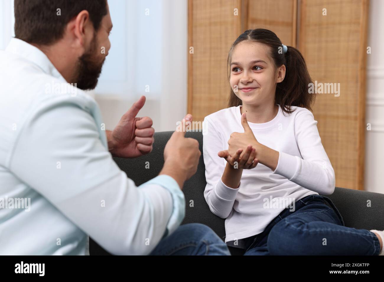 Man and his daughter using sign language for communication at home ...
