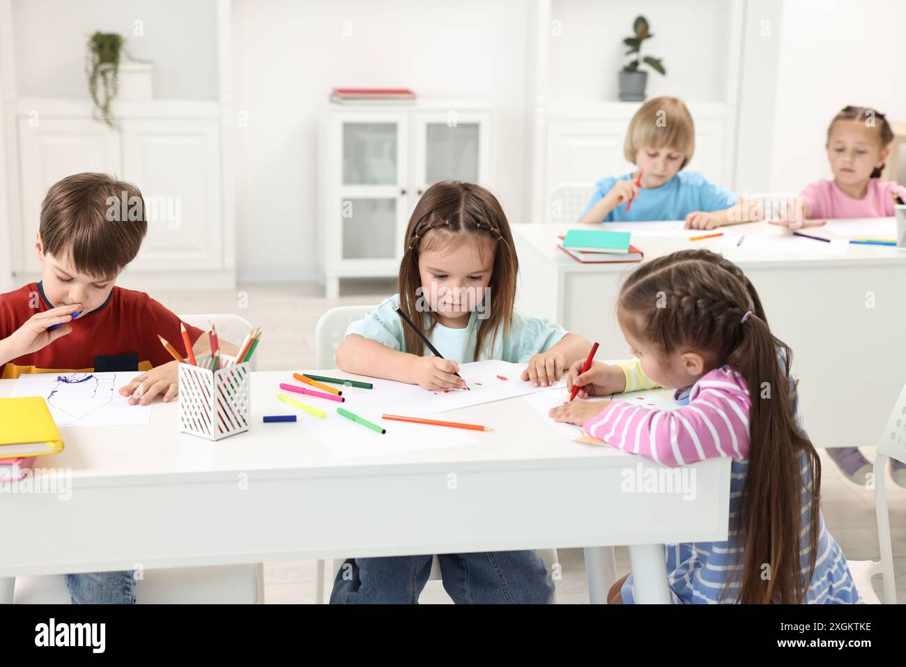 Group of children drawing at table indoors Stock Photo - Alamy