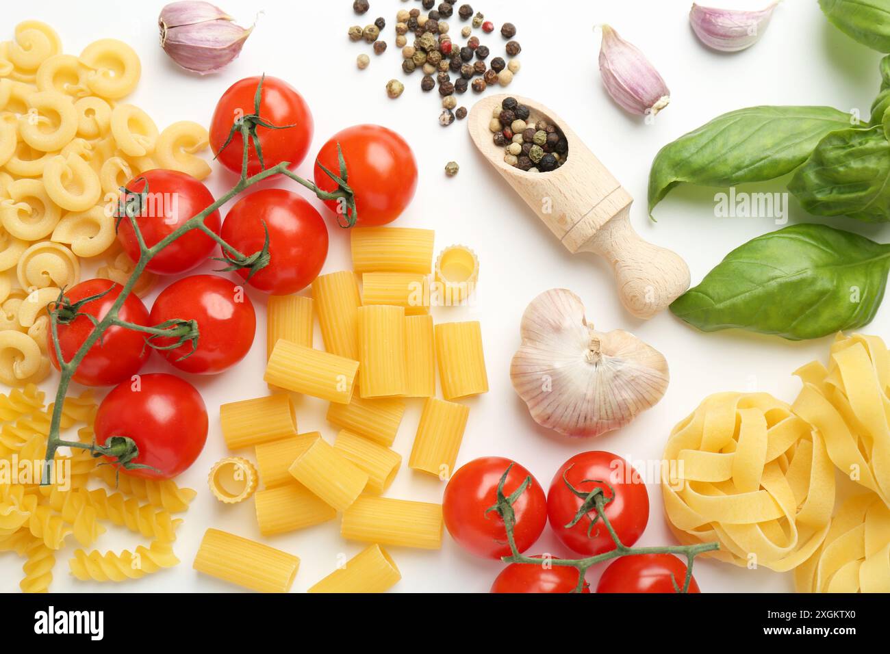Different types of pasta, spices and products on white background, top ...