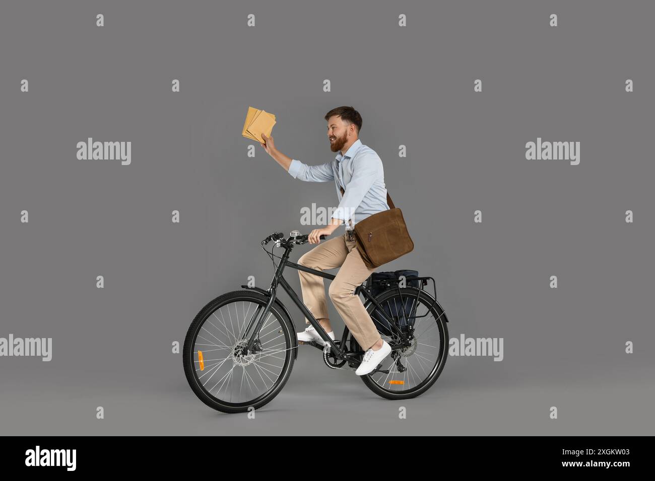Postman on bicycle delivering letters against grey background Stock ...