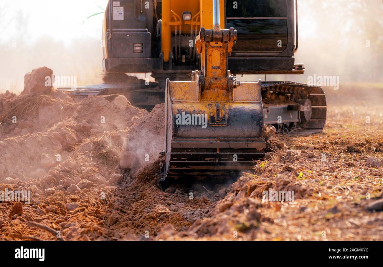 Metal bucket of backhoe digging soil. Excavator working at construction ...