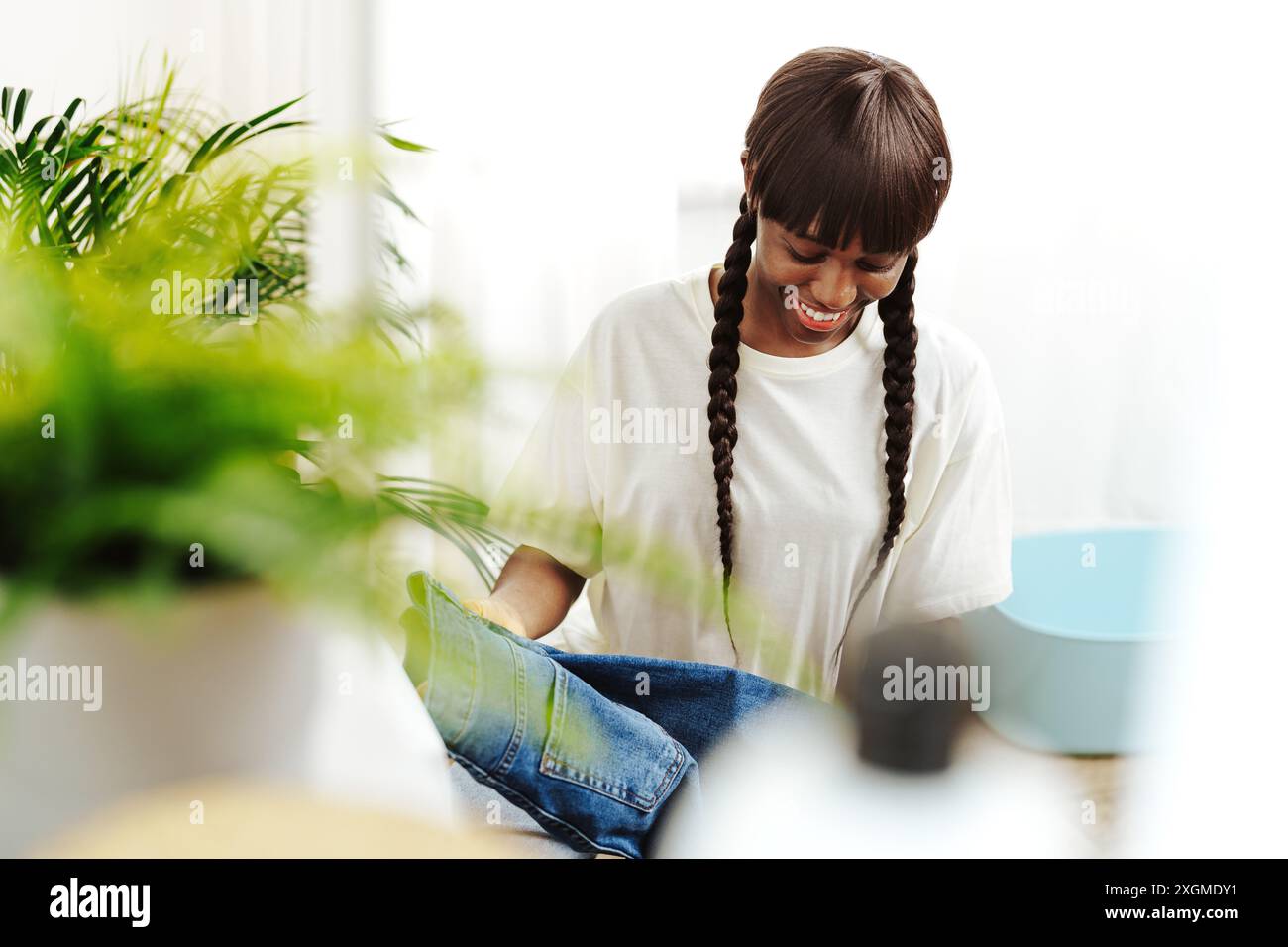 African Woman Folding Laundry After Washing Clothes in Modern Laundry ...