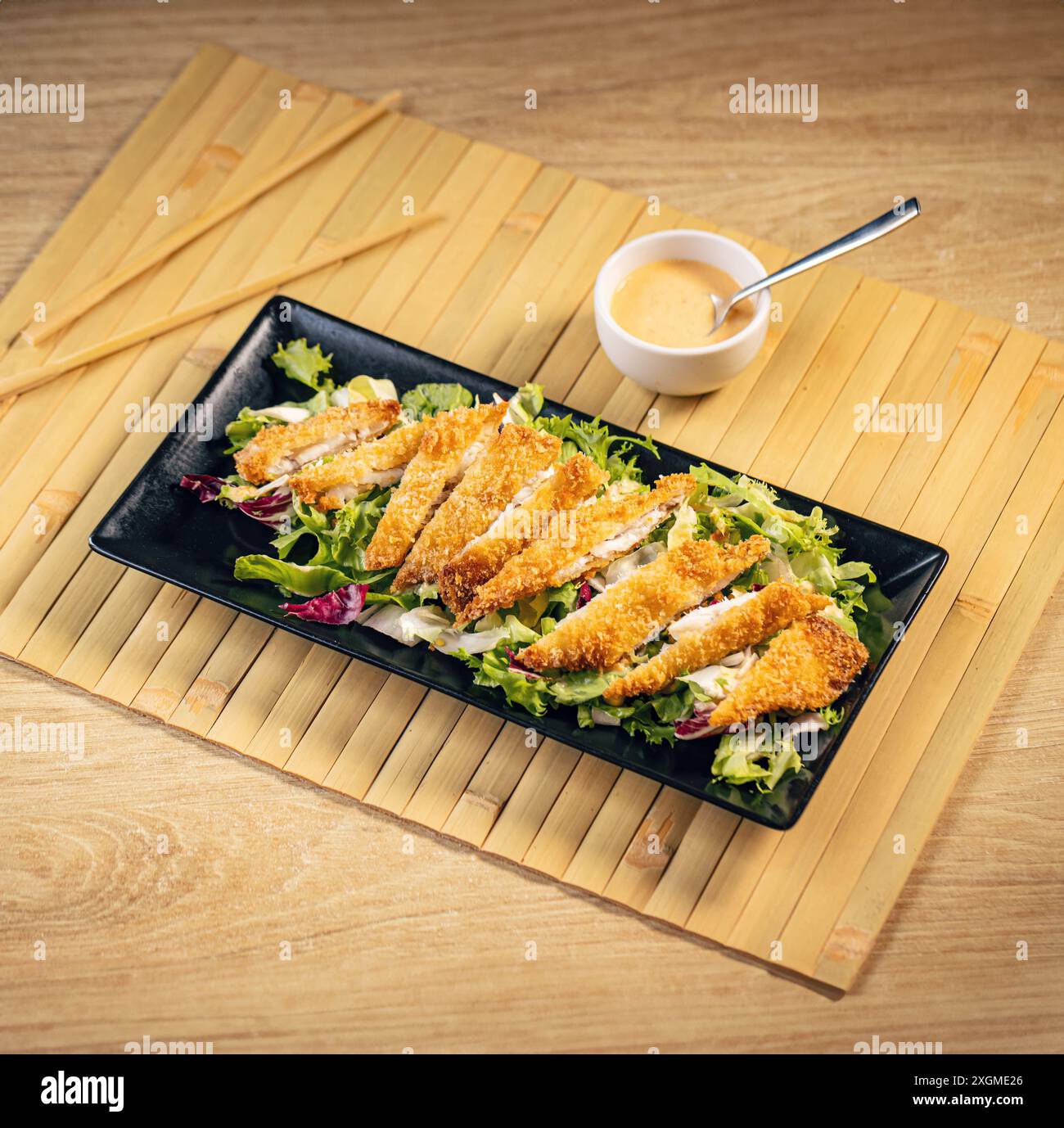 Asian style breaded chicken strips are served on a bed of lettuce Stock ...
