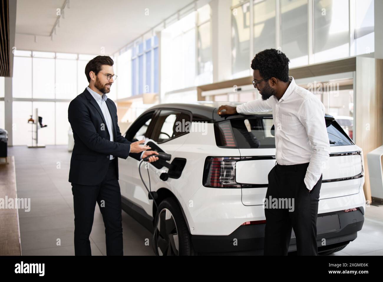 Dealer sells electric SUV to businessman in car dealership Stock Photo ...