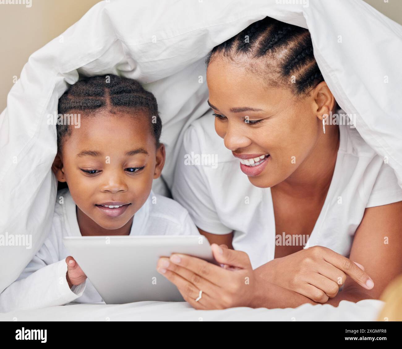 Black kid playing tablet lying hi-res stock photography and images - Alamy
