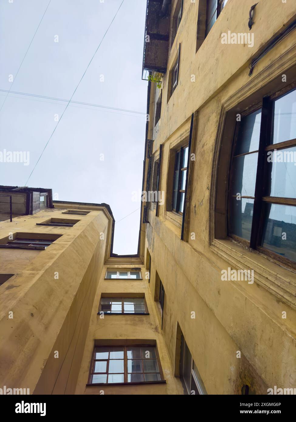 Upward perspective of an old yellow building featuring multiple windows ...