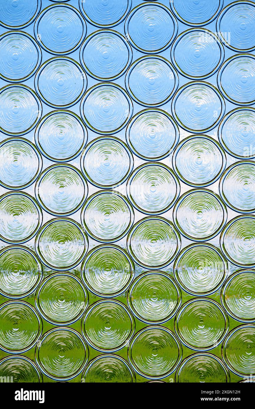 View through an opaque pane of glass, window pane, with green meadow ...