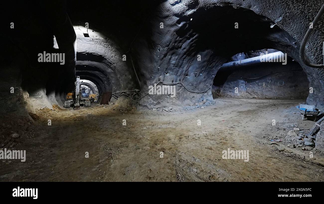 A vast underground tunnel with a rough texture and unlit passageways ...