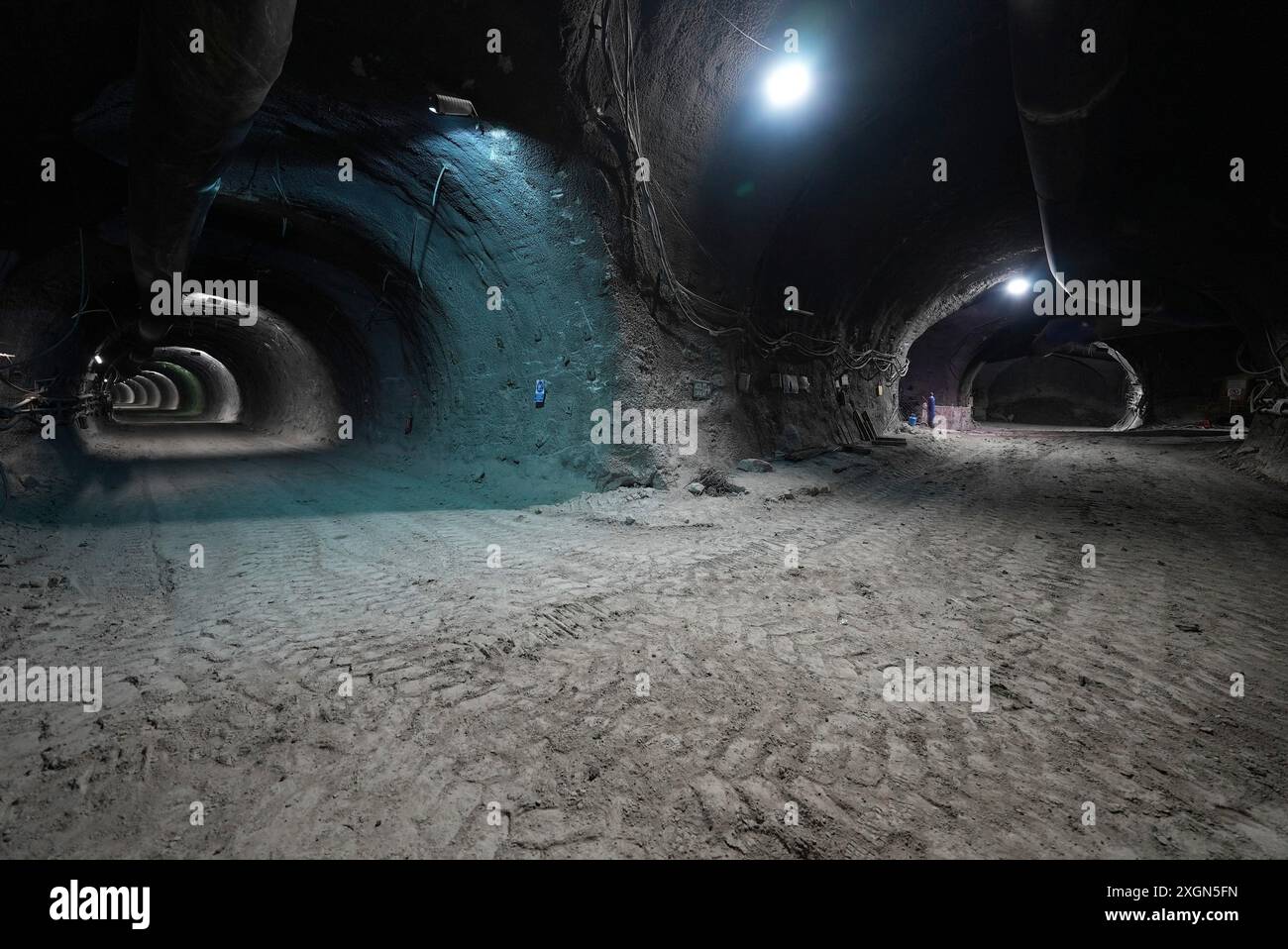 Dimly lit underground construction site with wide tunnels and visible ...