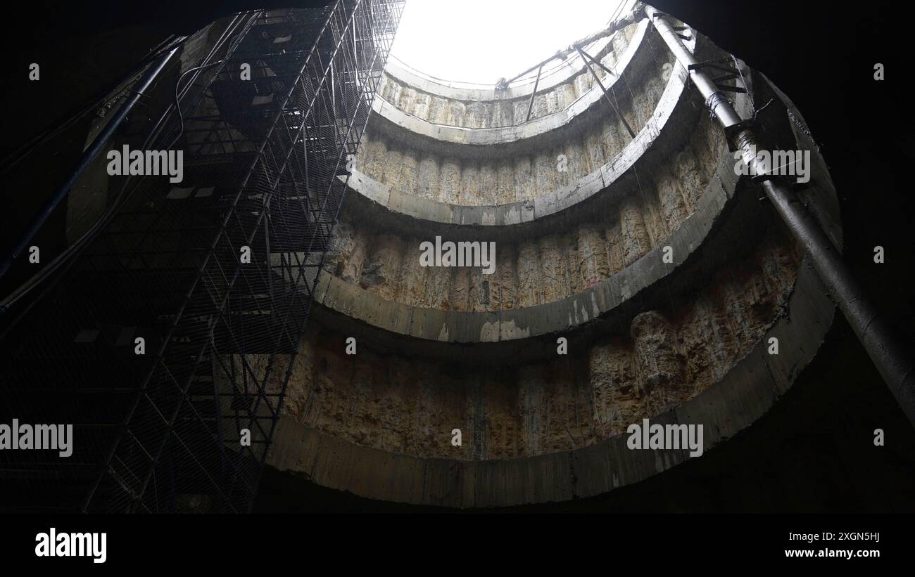 Looking up from the bottom of a cylindrical underground shaft with ...