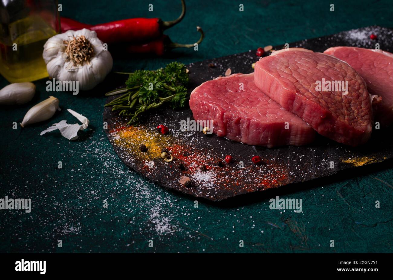 Fresh raw beef meat, Medallions, on black slate, with spices, close-up ...