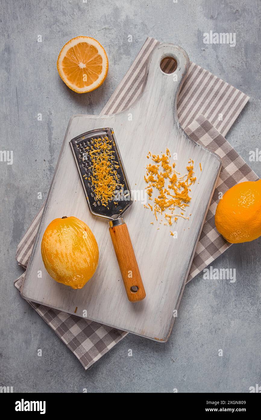 Grated lemon zest, on a cutting board, with a grater, top view, no ...