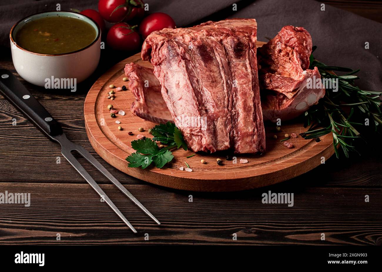 Smoked pork ribs, on a wooden table, top view, sauce, tomatoes and ...