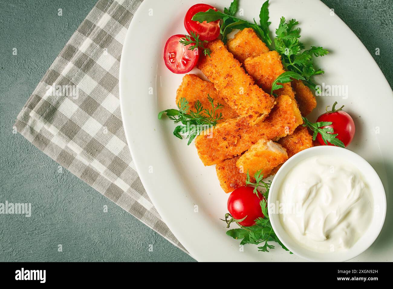 Fried fish nuggets, with white sauce, arugula and cherry, no people ...