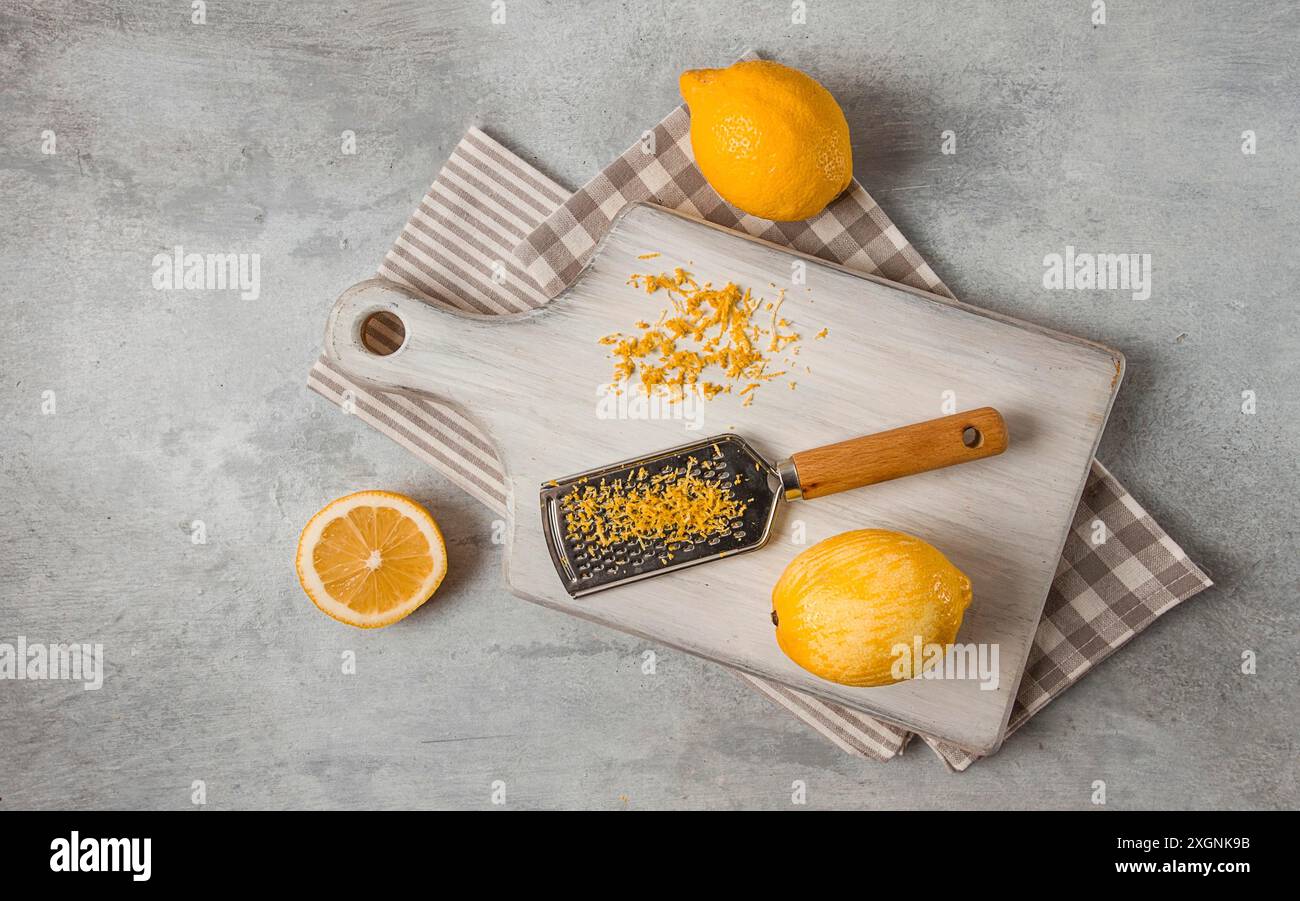 Grated lemon zest, on a cutting board, with a grater, top view, no ...