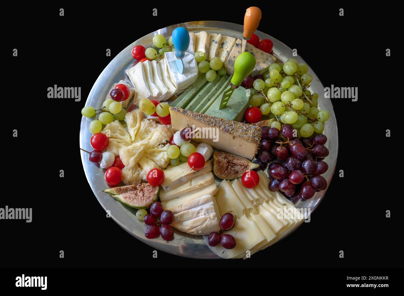 Cheese platter with different types of cheese and grapes on a black ...