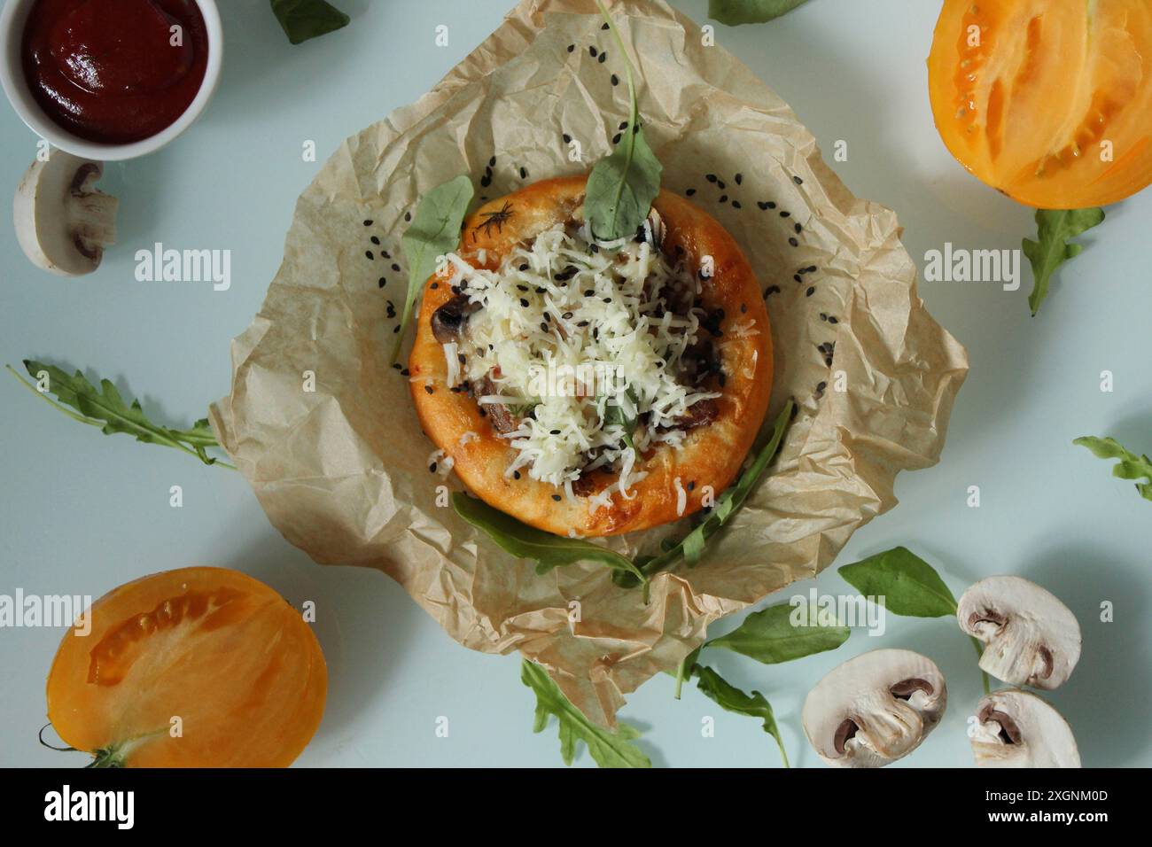 Bread topped with melted cheese and arugula, placed on parchment paper ...