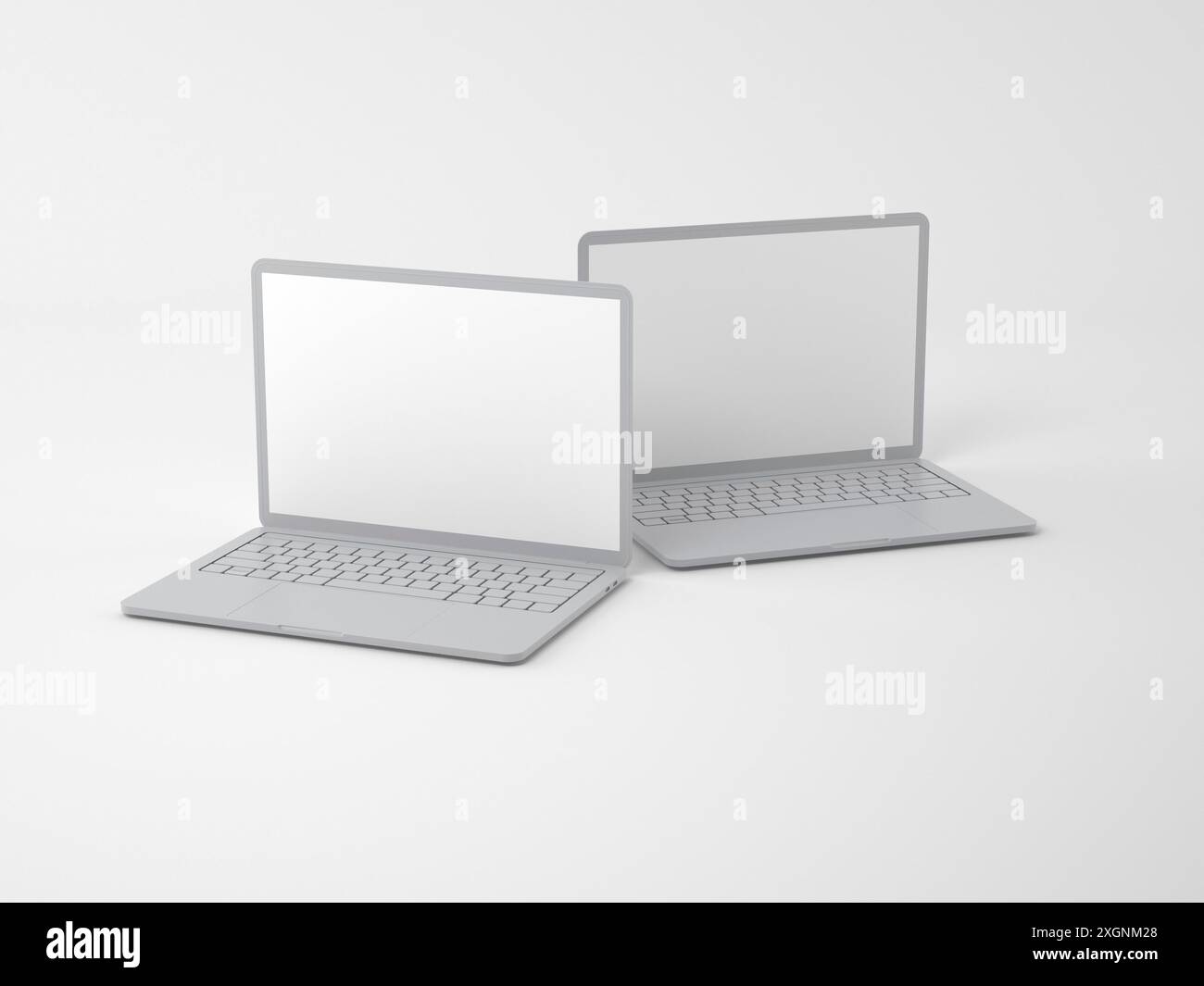 Two gray laptops placed side by side against a plain white background ...