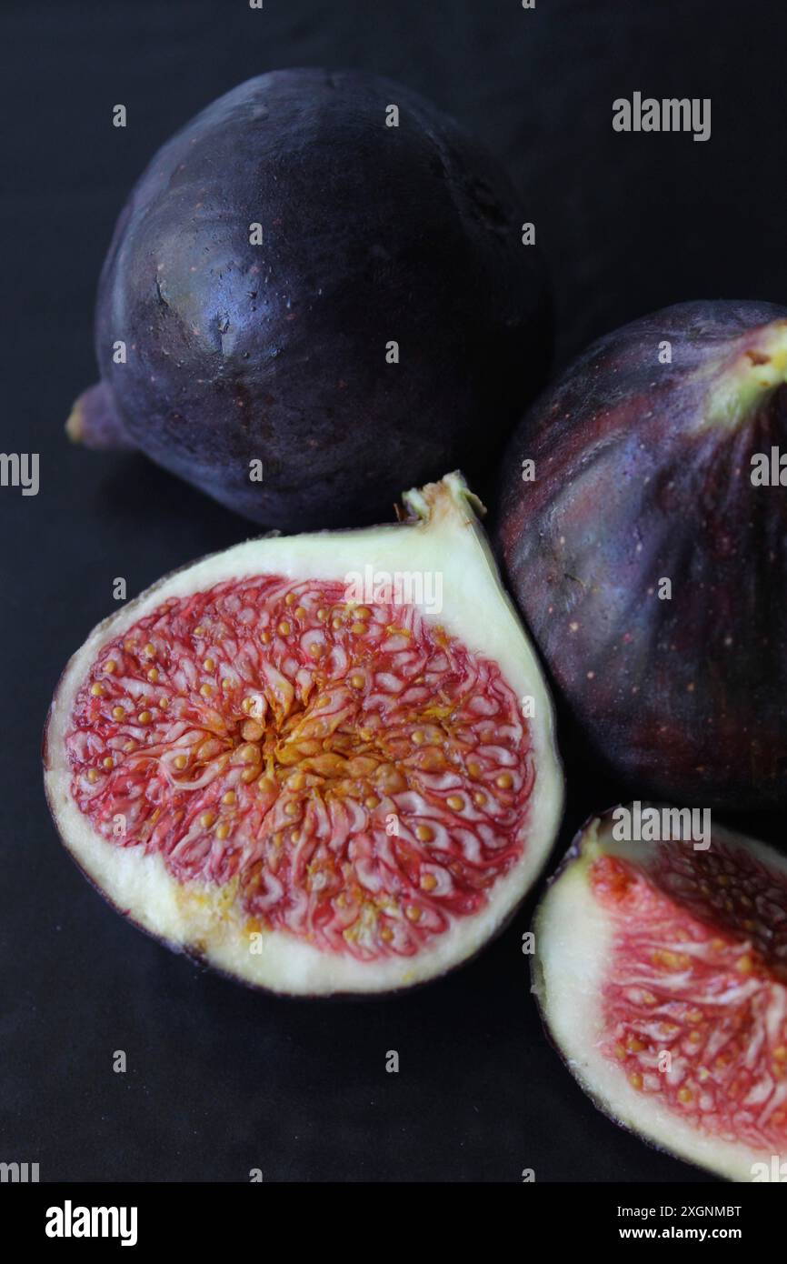 Close-up of fresh dark purple figs, some whole and some sliced ...