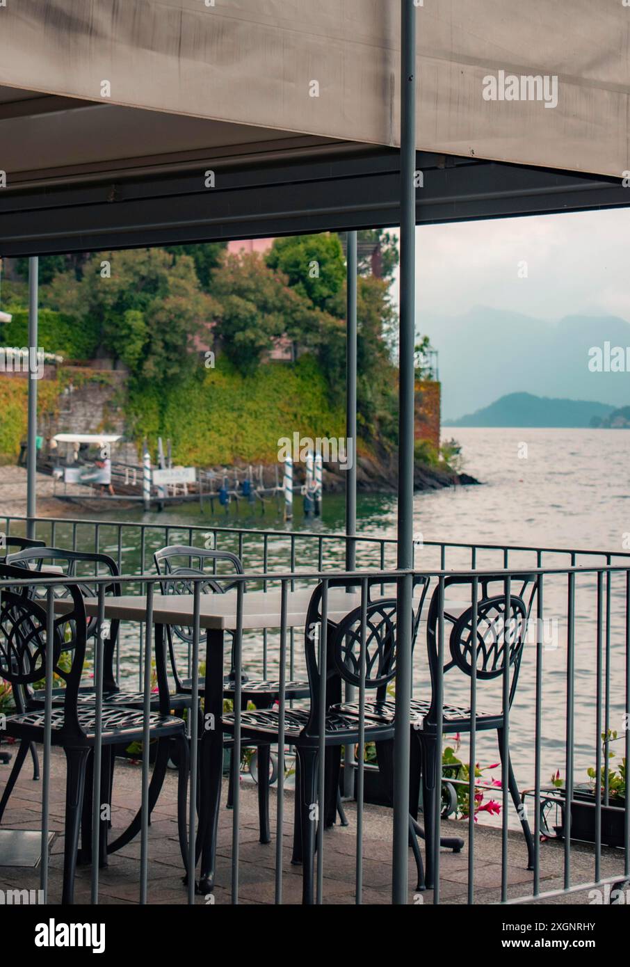 A terrace of a restaurant overlooking Lake Como, surrounded by green ...