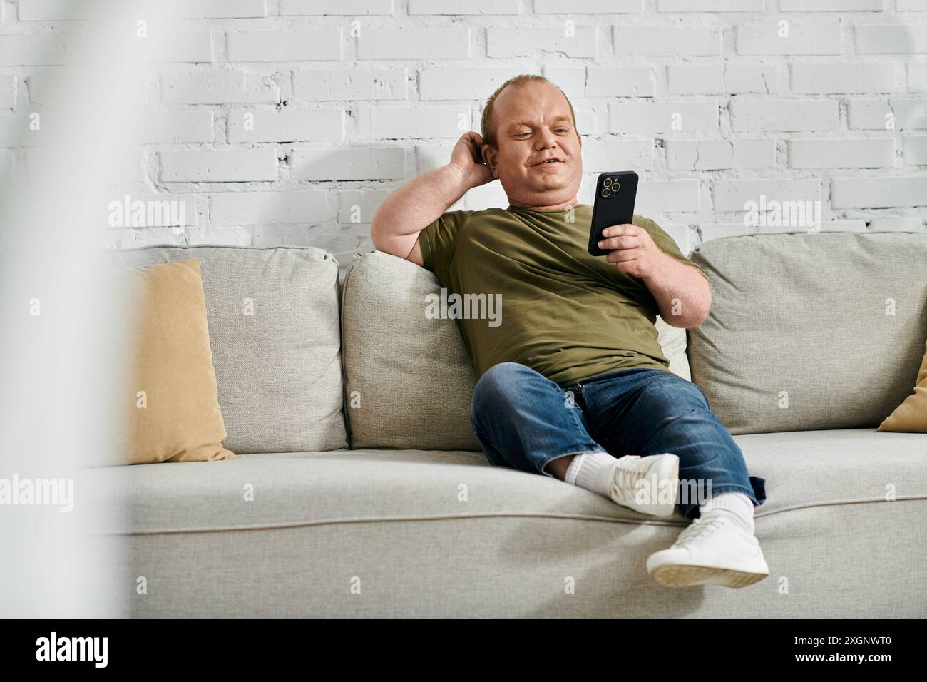 Man scrolling phone on sofa hi-res stock photography and images - Alamy