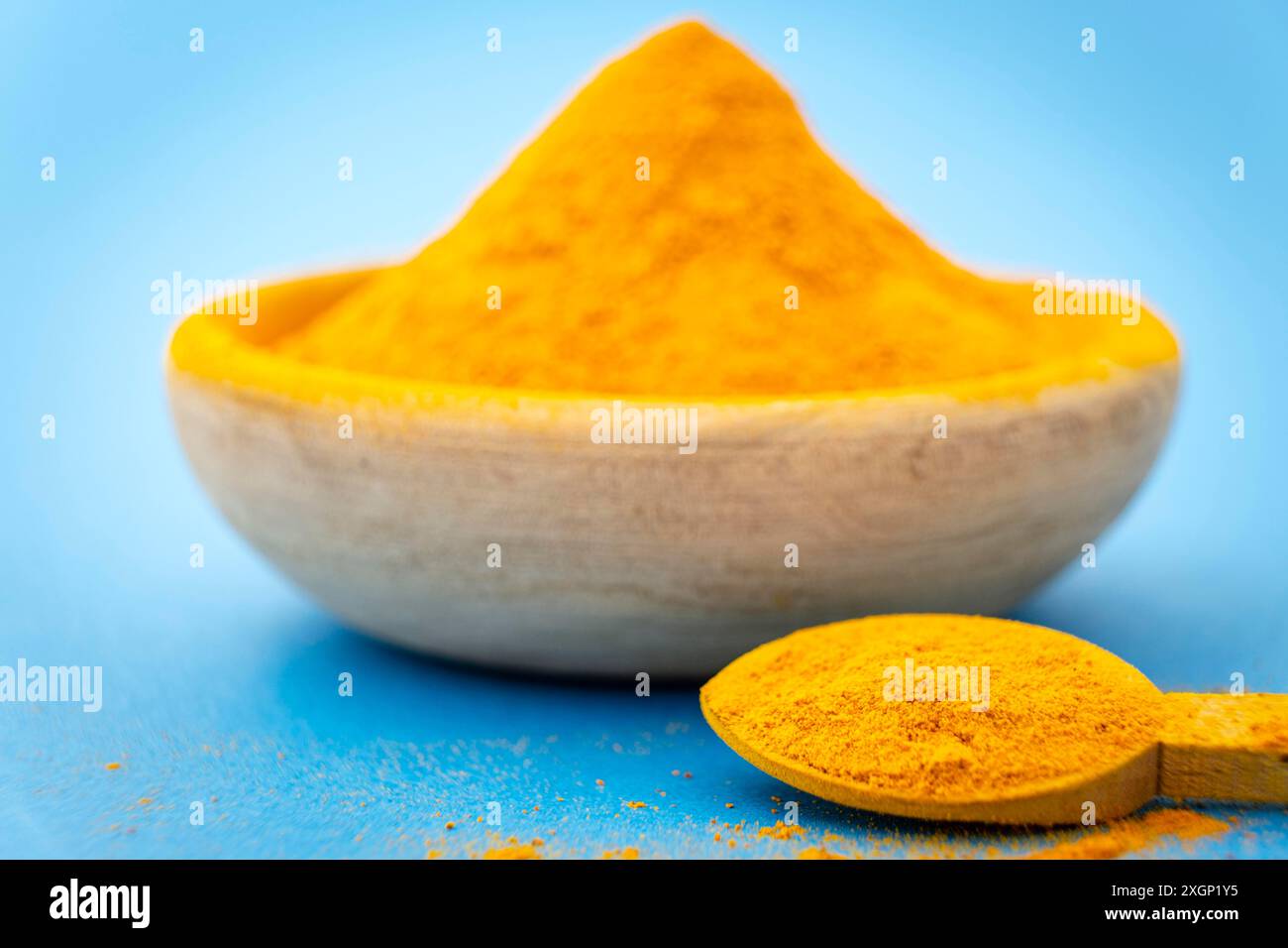 Ground turmeric on blue background Stock Photo - Alamy