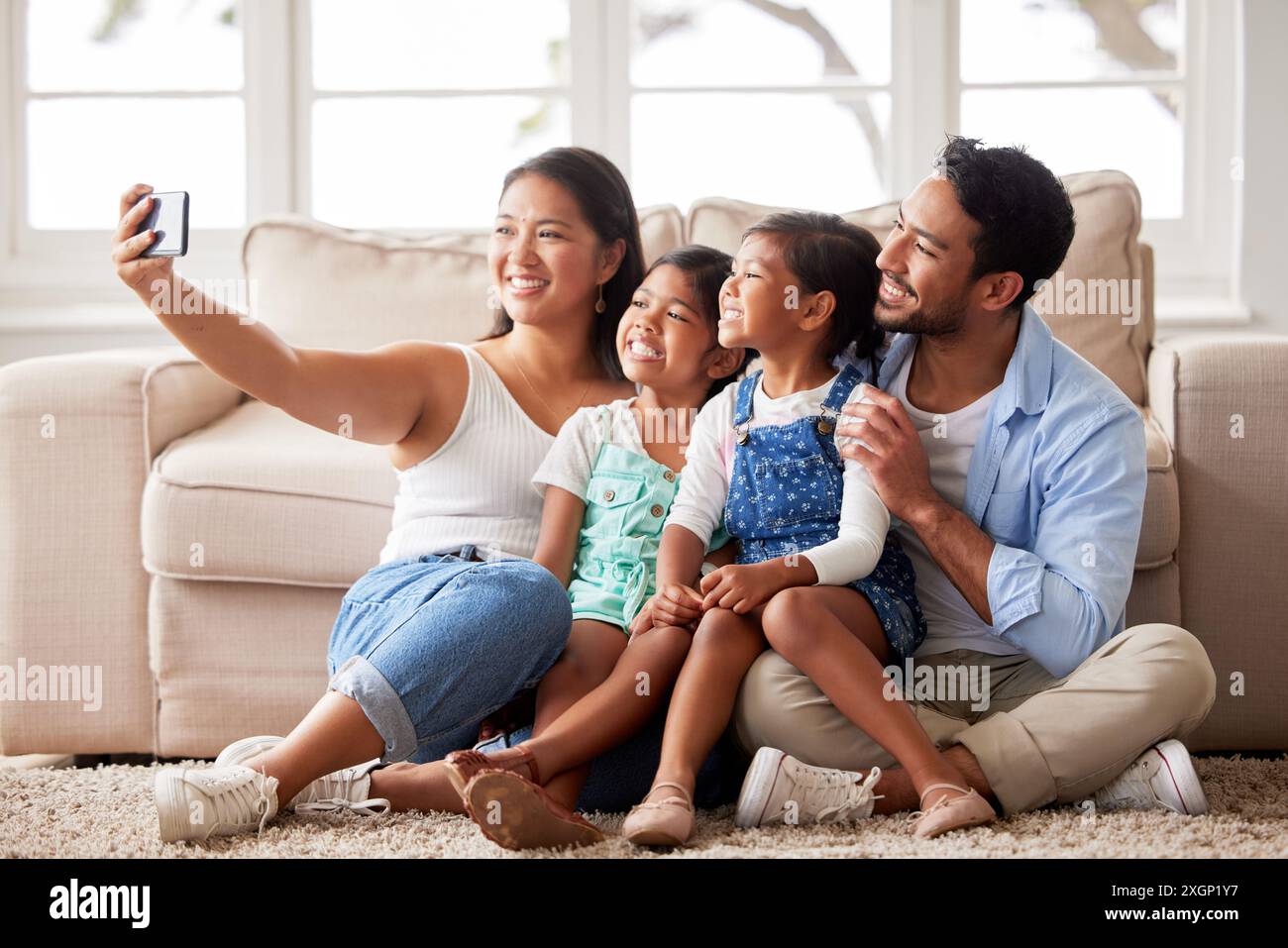 Selfie, home and mom, dad and children by sofa for social media ...
