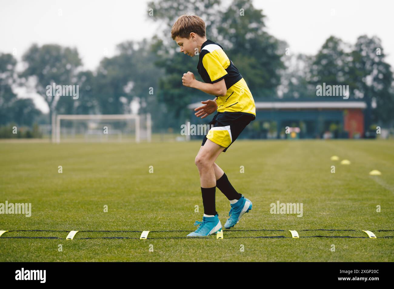 Youth soccer player skipping on training ladder. Young boy running fast ...