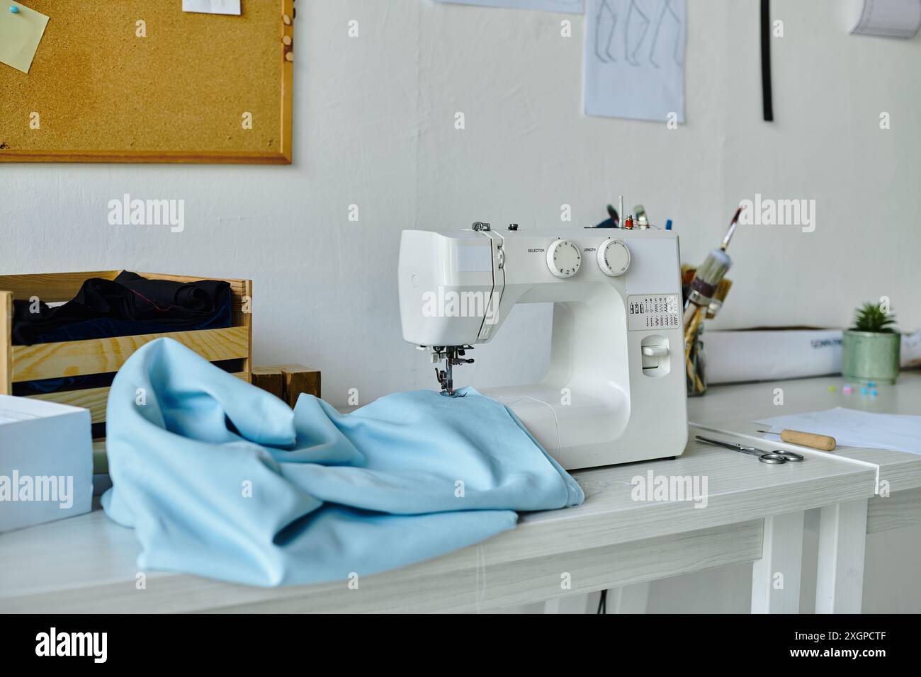 A white sewing machine sits ready for action on a clean, white ...