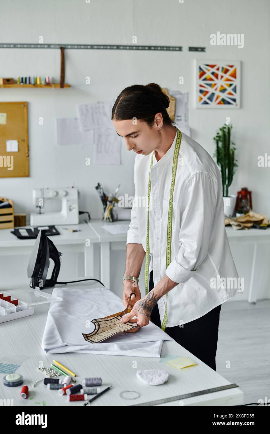 A young man in a white shirt works on a clothing restoration project in ...