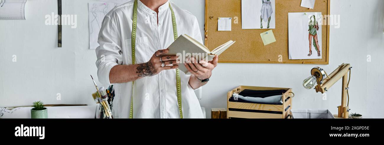 A young man, owner of a DIY clothing restoration atelier, reads a book ...
