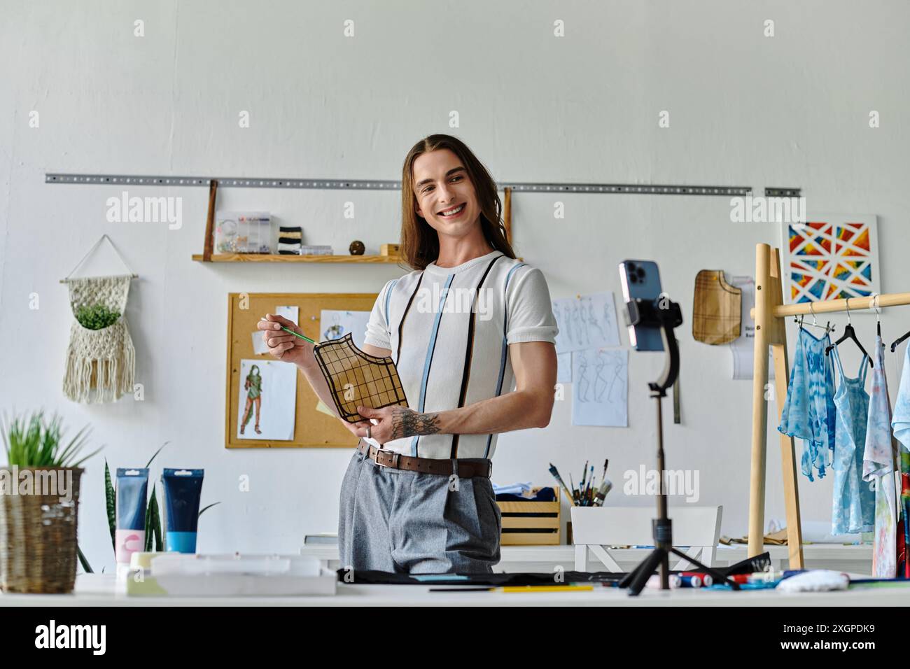 A young man, owner of a DIY clothing restoration atelier, smiles while ...