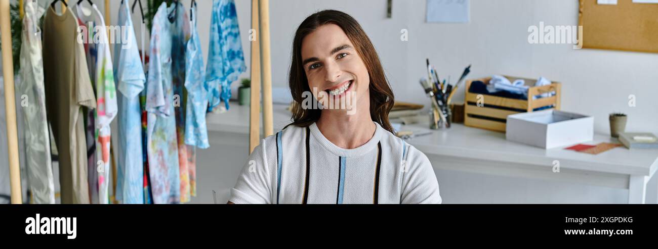 A young man smiles proudly in his DIY clothing restoration atelier ...
