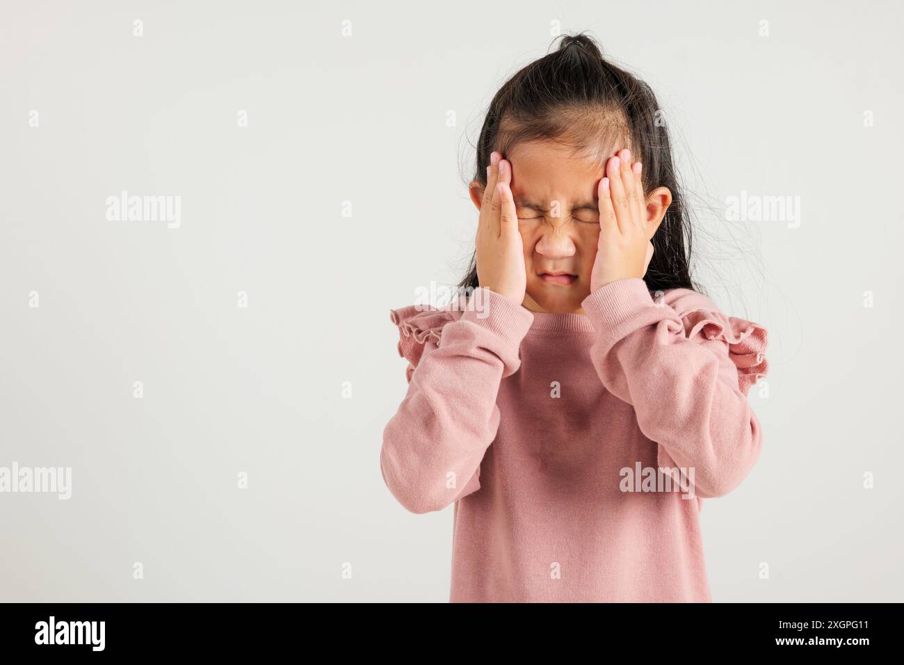 Portrait of Asian young kid girl sad tired strain face holding hold ...
